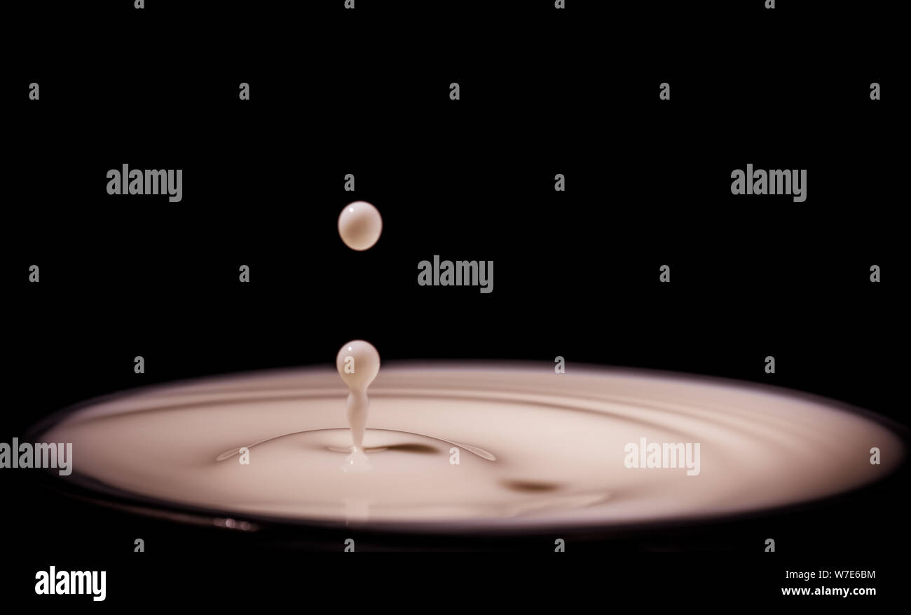 Drop of milk - milk droplet falling on white liquid and creating splash ...