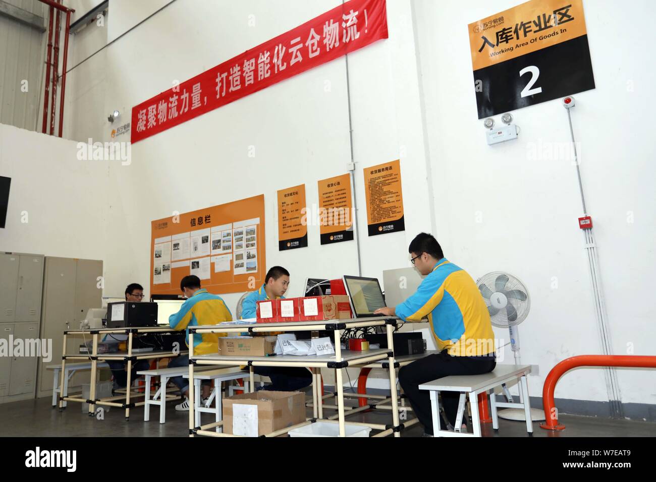 Chinese employees work on computers in the largest smart logistics base ...