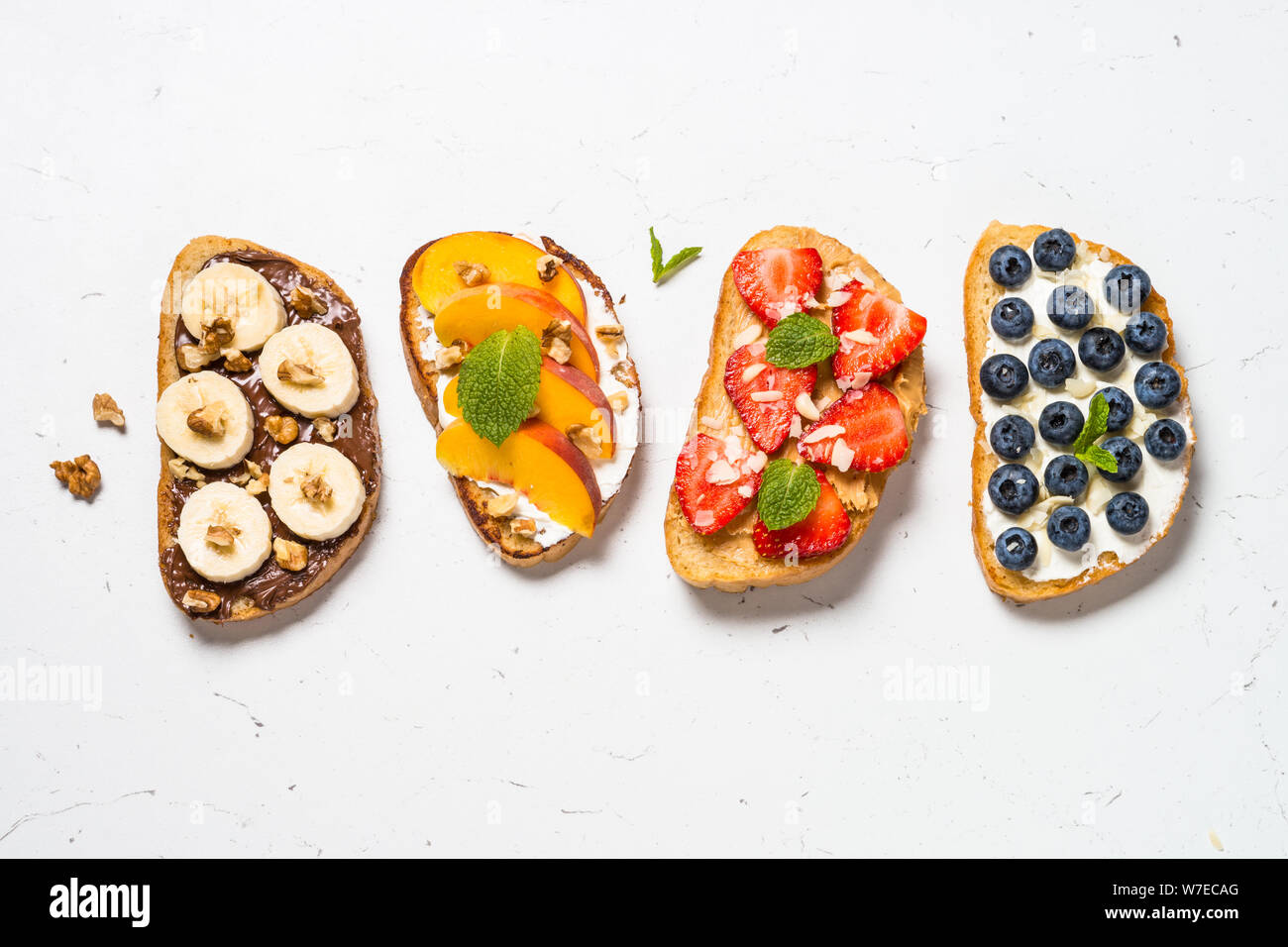 Sweet toast assortment with fresh fruit and berries on white Stock ...
