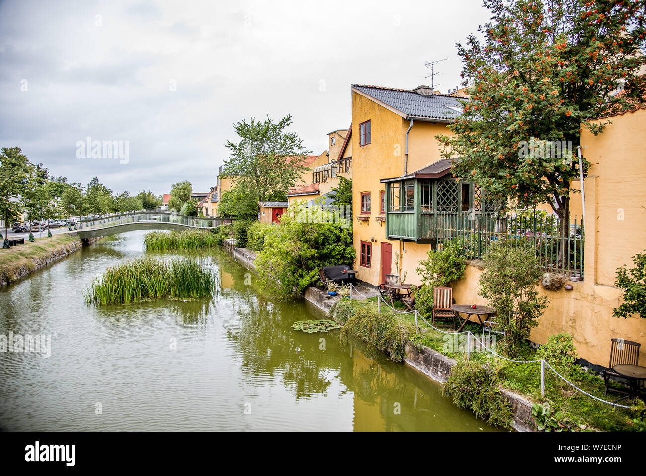a picturesque canal and bridge along old yellow houses at ...