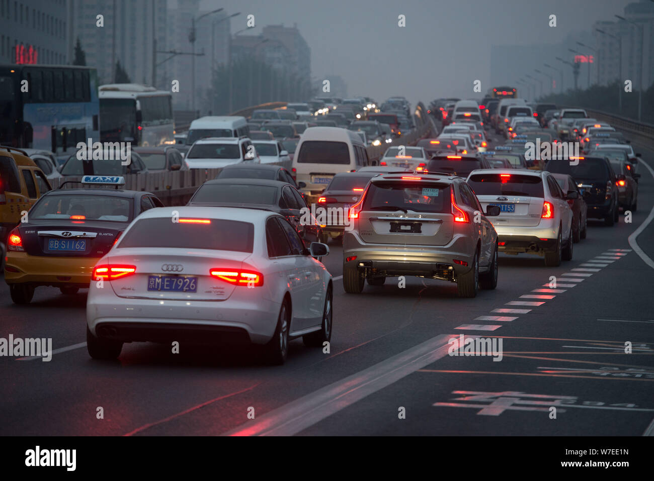 Masses of vehicles move slowly on a road in a traffic jam during rush ...
