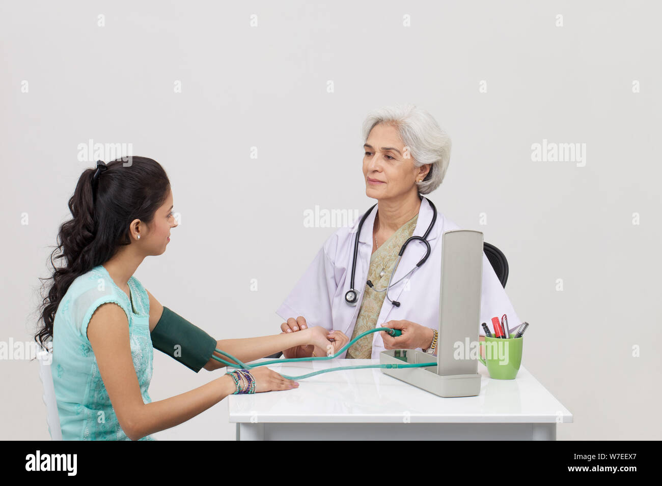 Female doctor checking patient blood pressure Stock Photo - Alamy