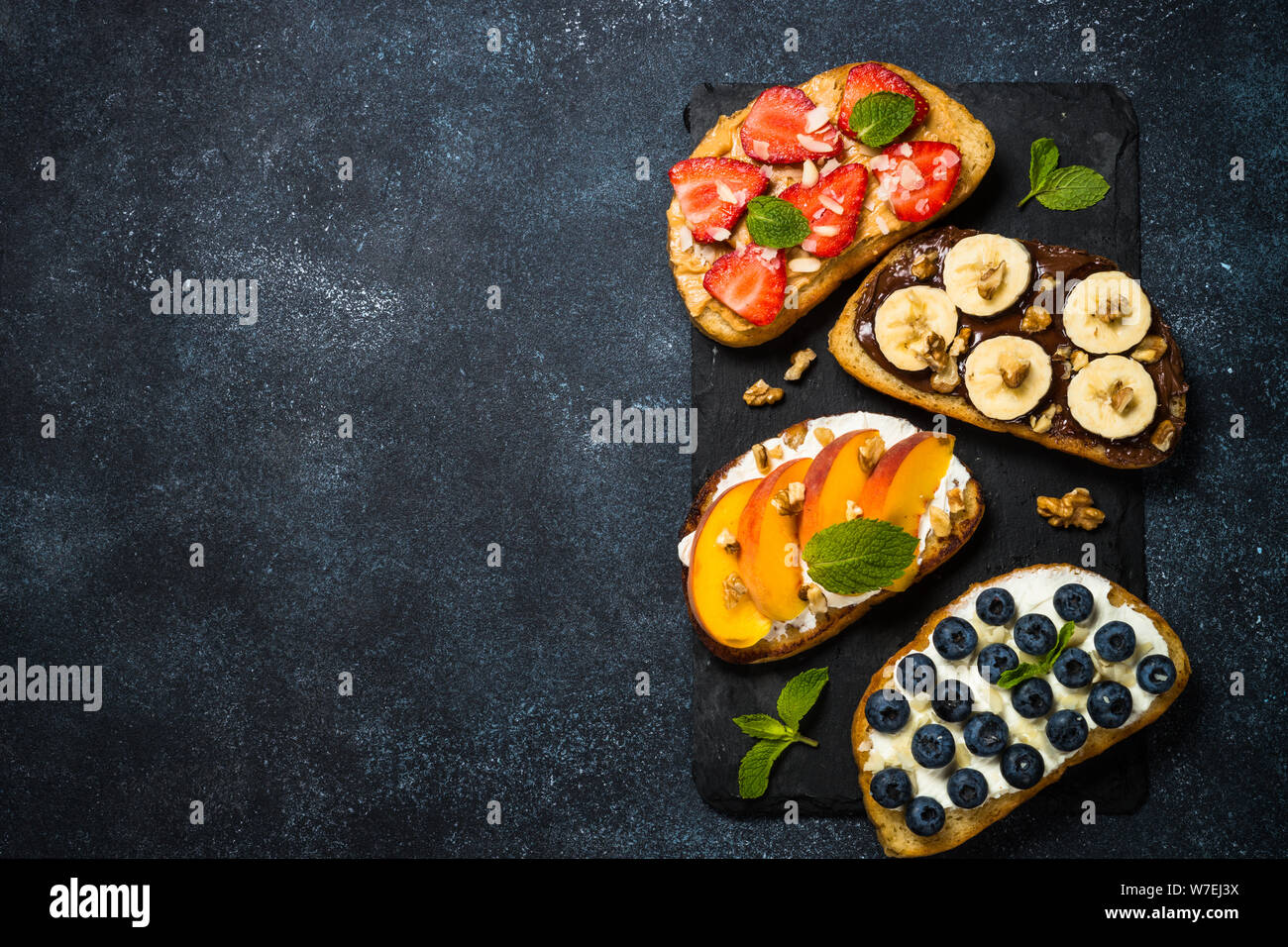 Sweet toast assortment with fresh fruit and berries on black Stock ...
