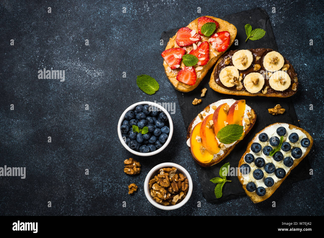 Sweet toast assortment with fresh fruit and berries on black Stock ...