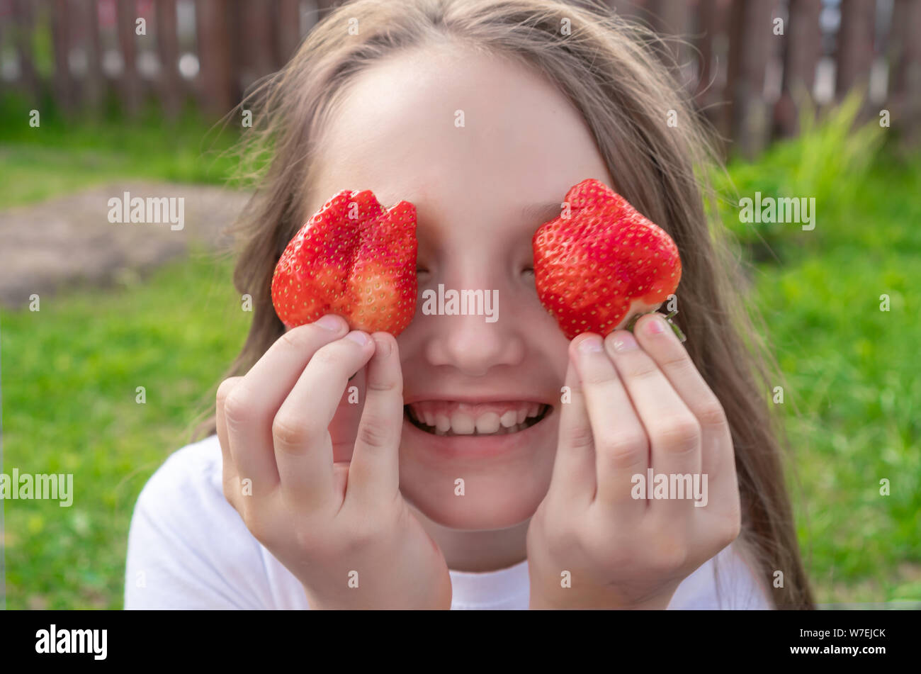 Strawberry Eyes . Beautiful young girl holding strawberries in eyes ...