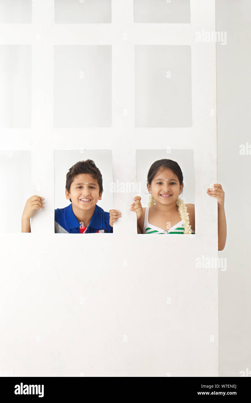 Children peeking behind a door Stock Photo - Alamy