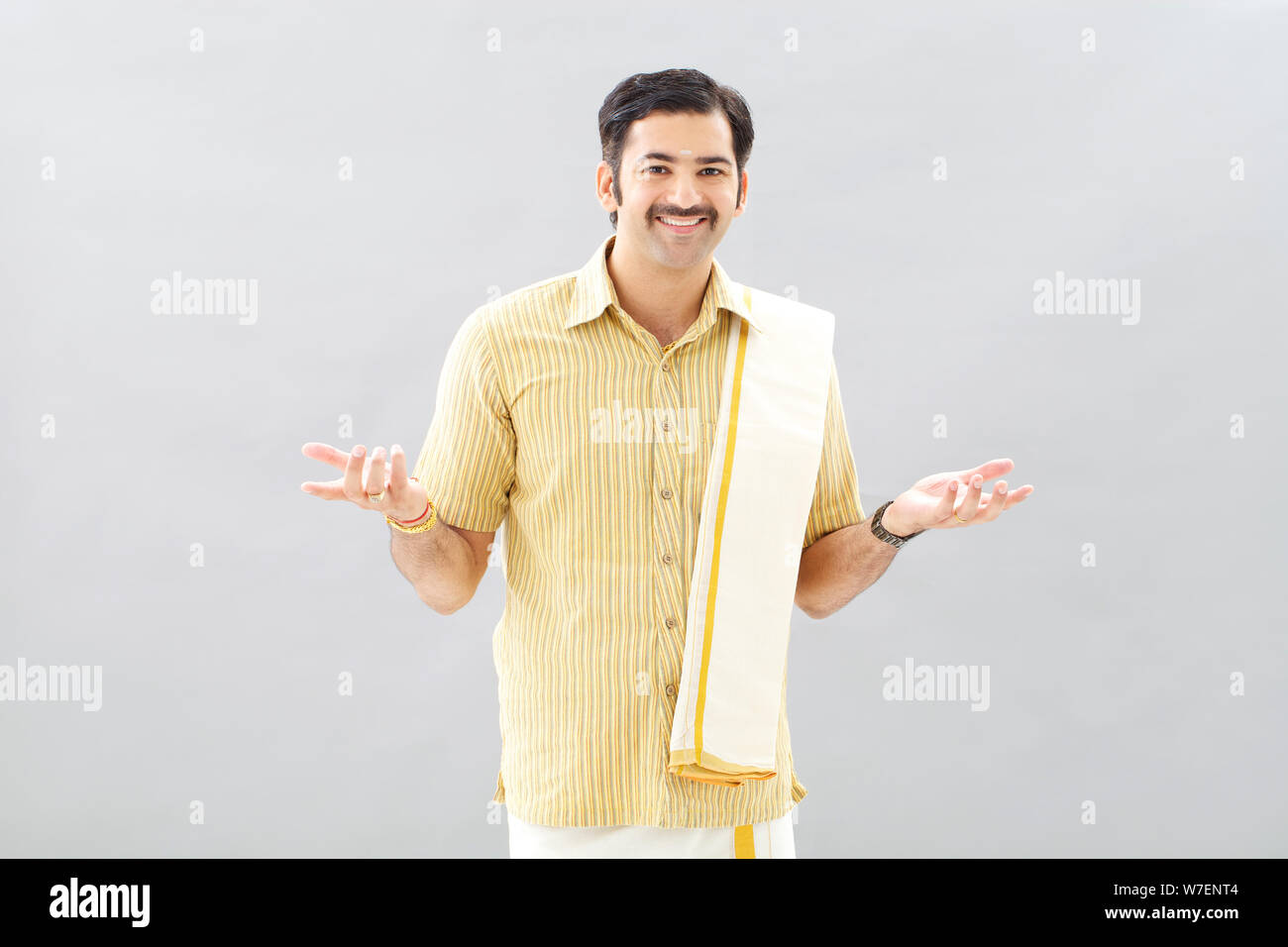South Indian man smiling with his arm outstretched Stock Photo - Alamy