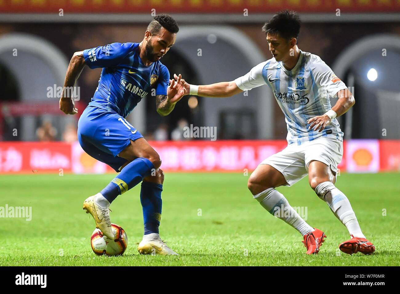 Brazilian football player Alex Teixeira, left, of Jiangsu Suning passes ...