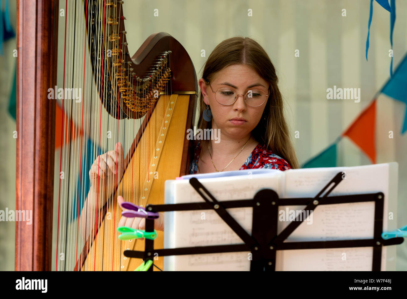 A young woman performer playing a harp Stock Photo - Alamy