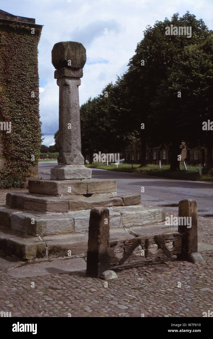Old cross and stocks in village market square, Ripley, Yorkshire, 20th ...