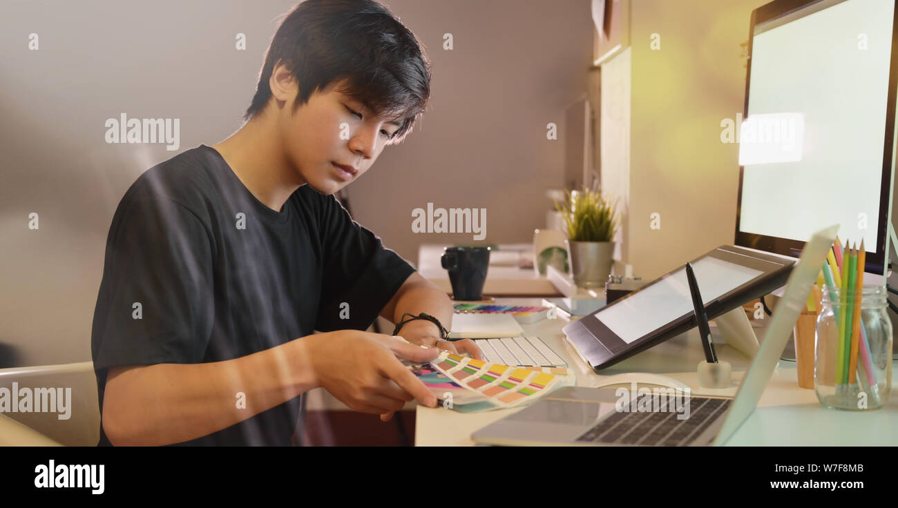 Young professional photographer working on his images with colour ...