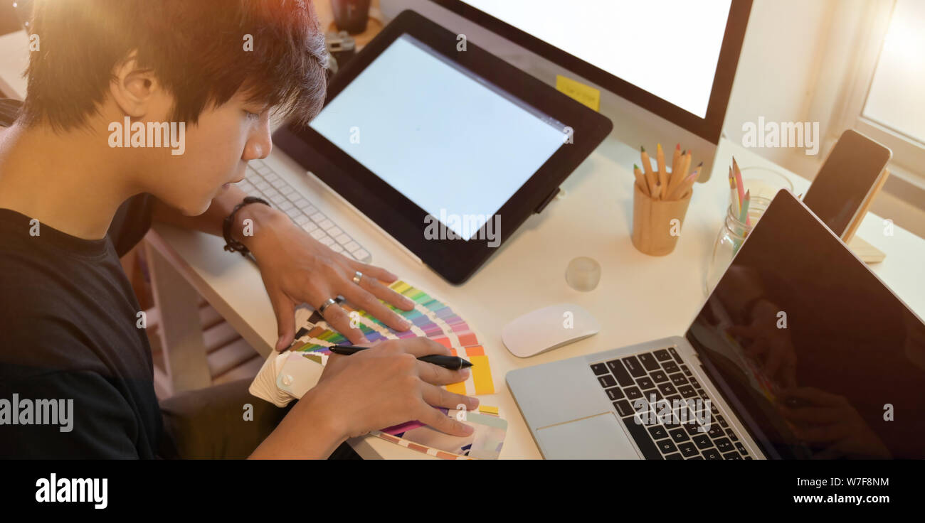 Young professional photographer working on his project with colour ...