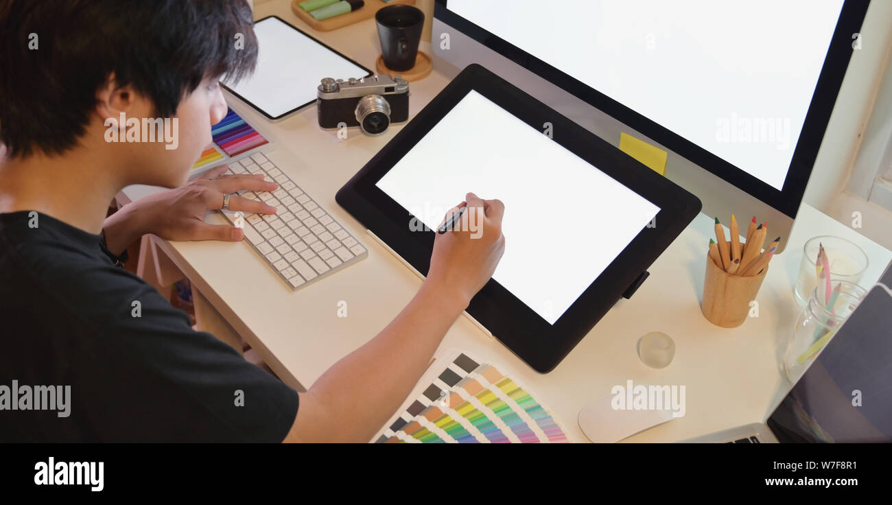 Young professional photographer editing his project in graphic tablet ...