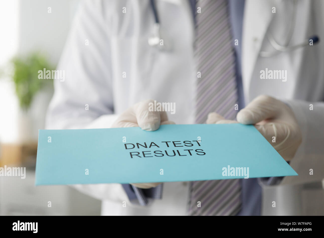 Male doctor hand holds out an envelope Stock Photo - Alamy