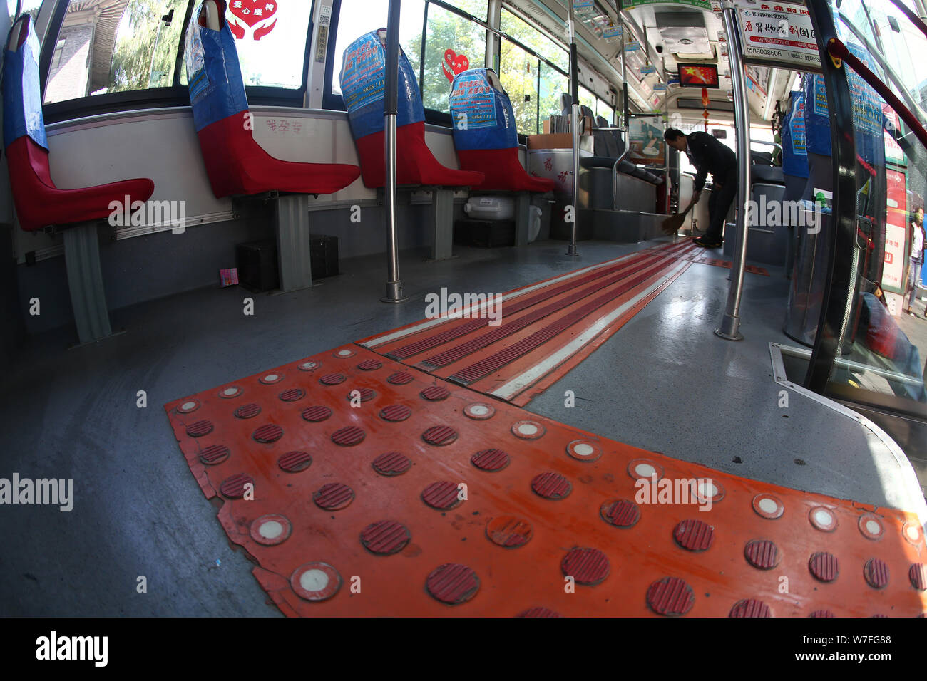 Chinese bus driver Yang Hongtao cleans the tactile paving designed and ...
