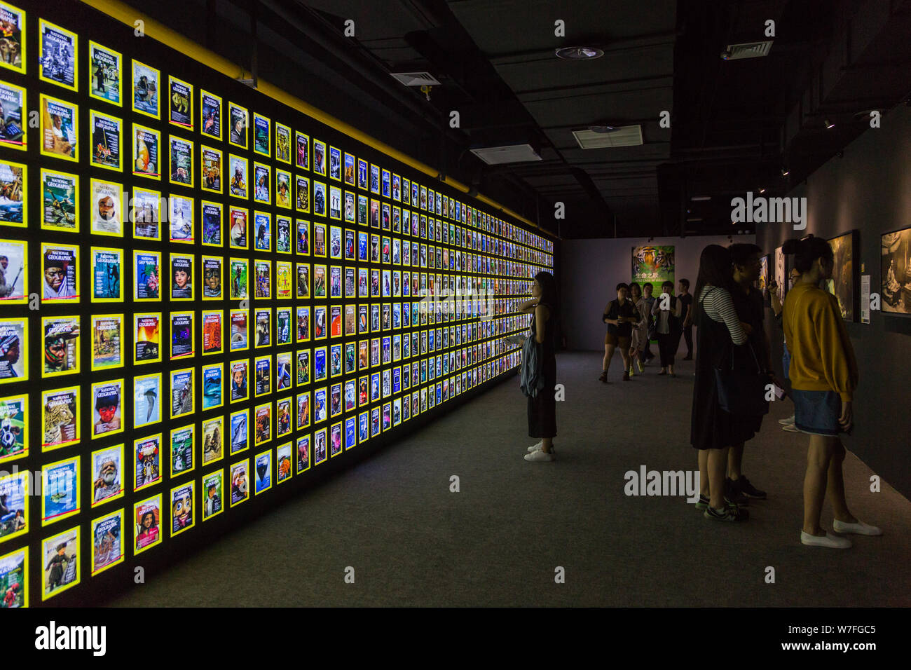 Visitors look at the covers of National Geographic Magazine in the ...