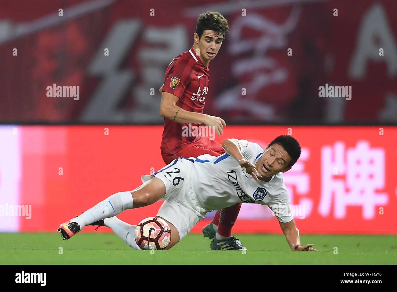 Brazilian football player Oscar, back, of Shanghai SIPG, challenges Cao ...