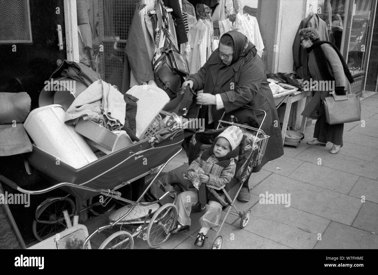 1970s poverty UK. Mixed race working class family mother and child out ...