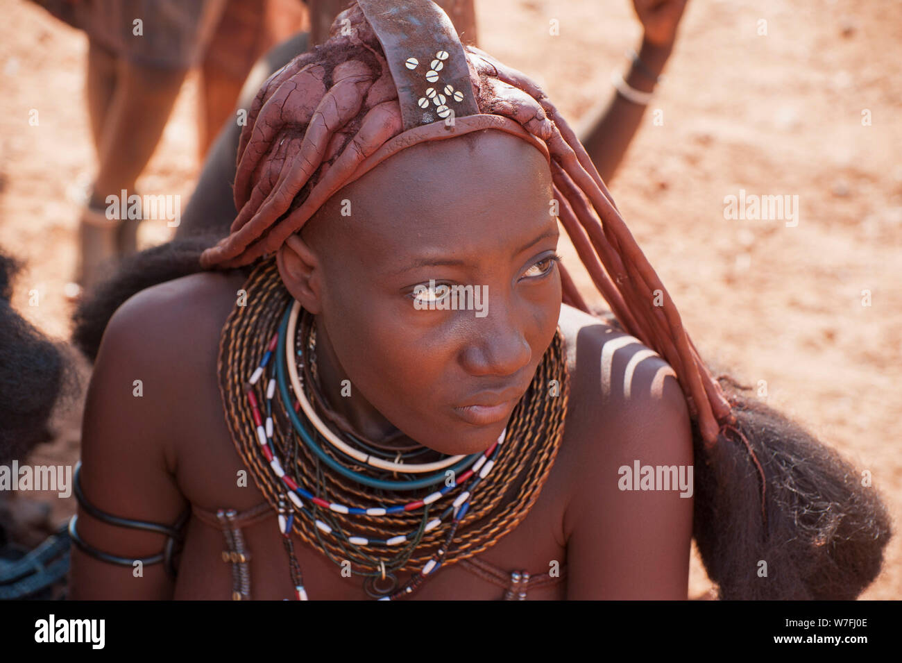 Young Himba woman wearing headgear and decorations. The Himba are a pastoral and nomadic people ...