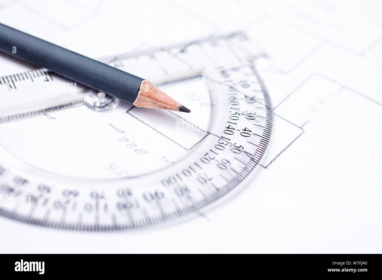 Pencil on a transparent protractor against the background of drawing ...