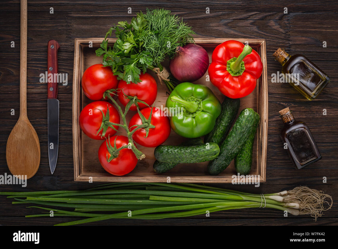 Set of fresh salad products. Fresh vegetables in a wooden box, a bottle ...