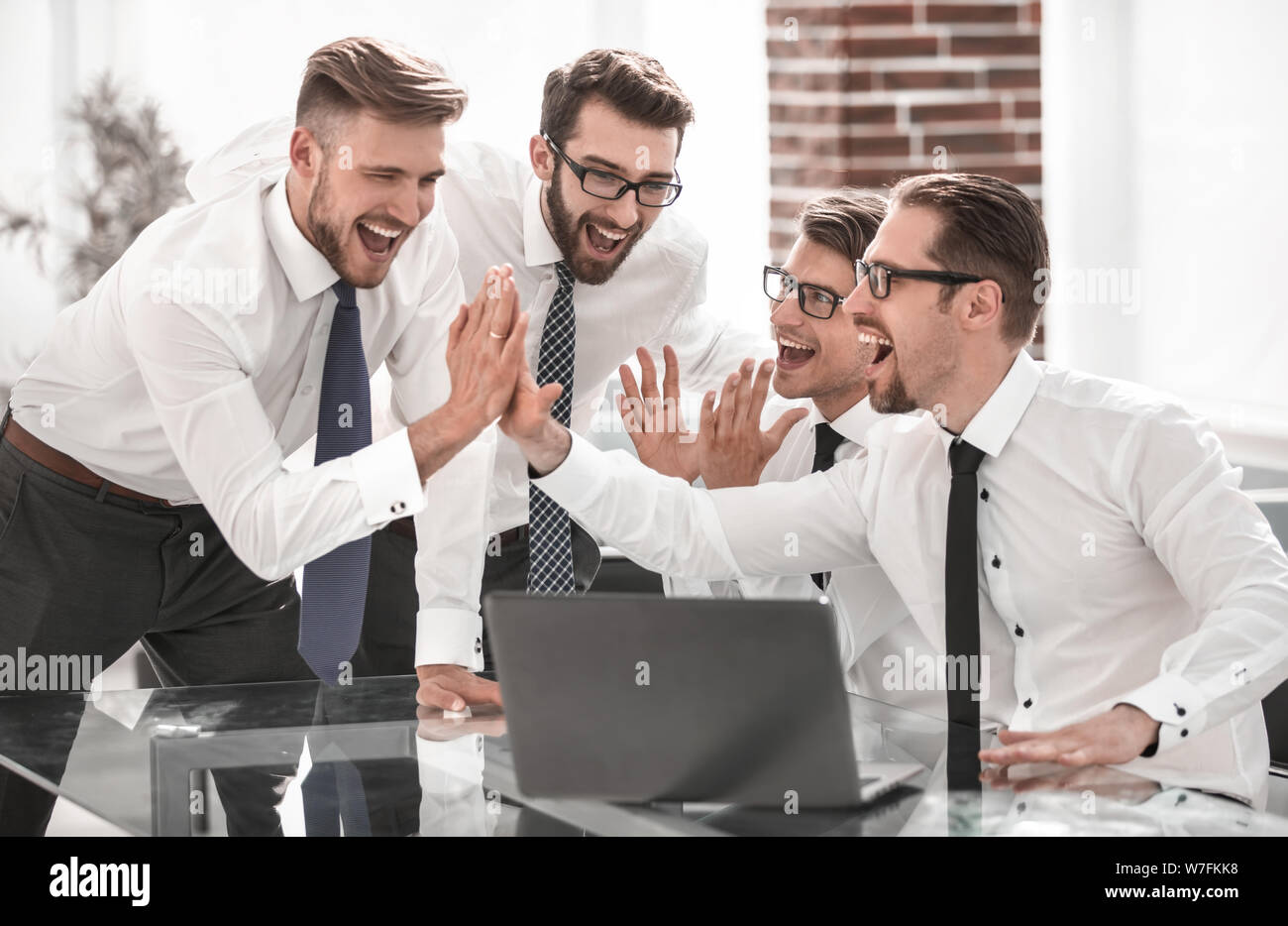 Happy excited business team, gives each other a high five Stock Photo ...