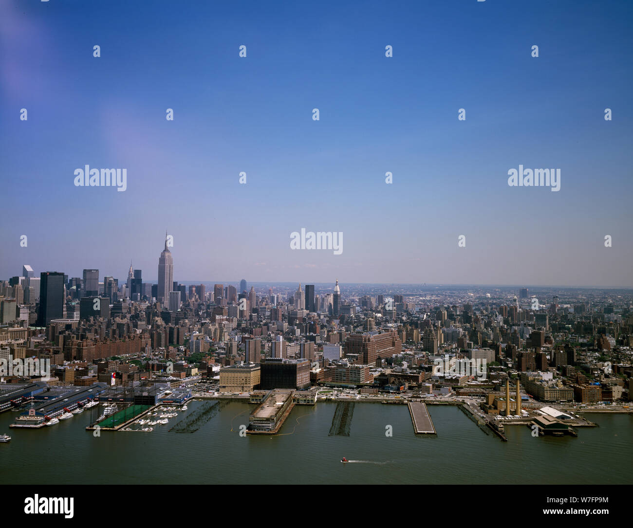 Aerial view of New York City from the East River. The Empire State Building is prominent on the ...