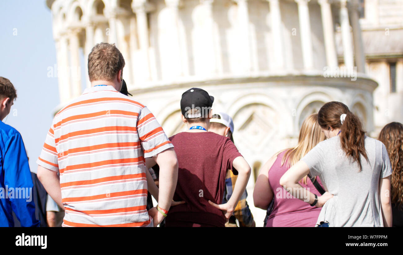 Crowd of people stay under the leaning tower of Pisa - Back view Stock ...
