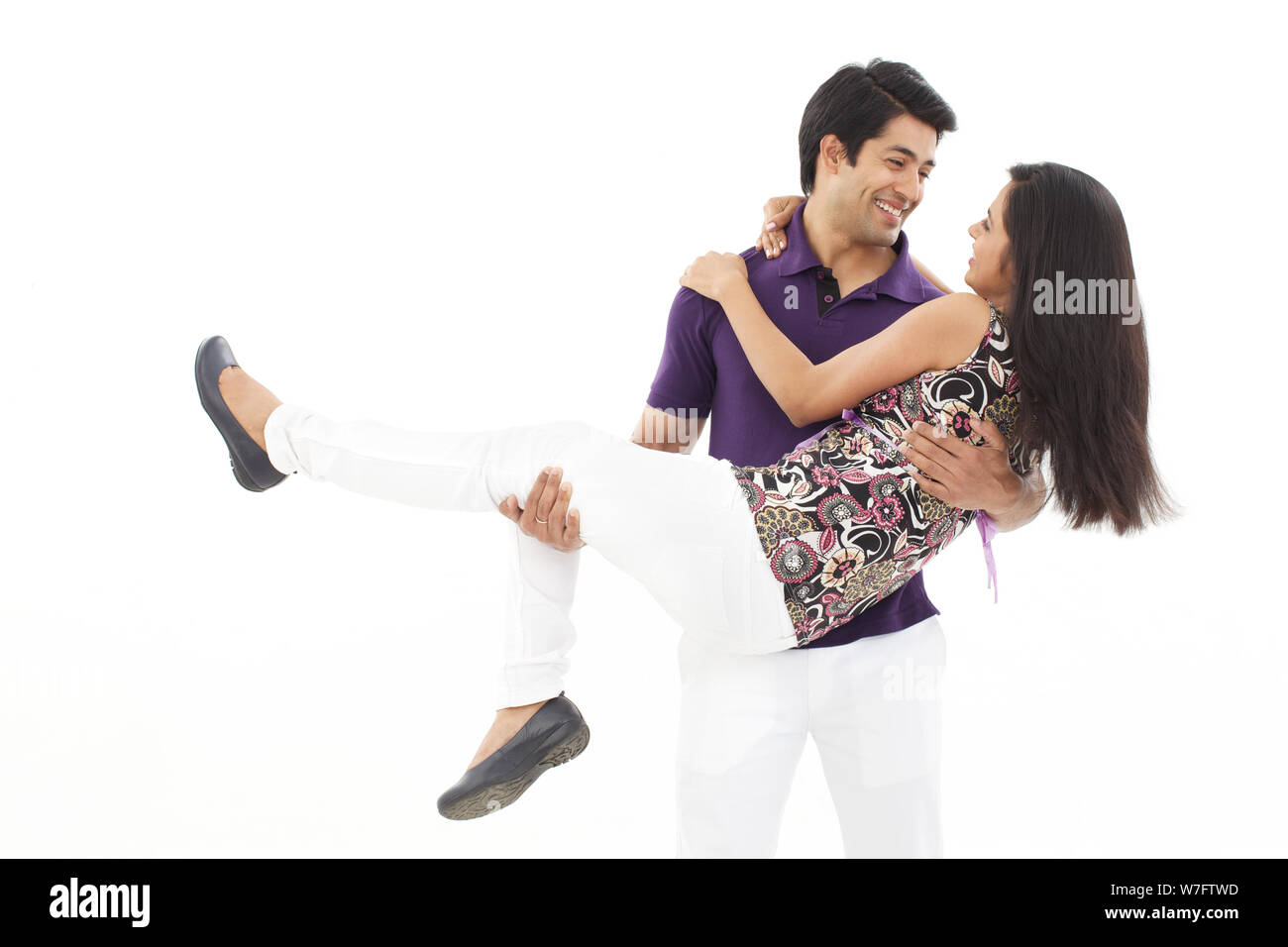 Young man carrying his girlfriend isolated on white background Stock ...
