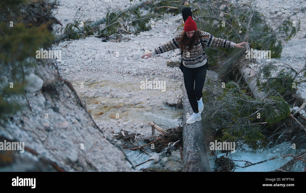 A young woman crossing the river on the log Stock Photo - Alamy