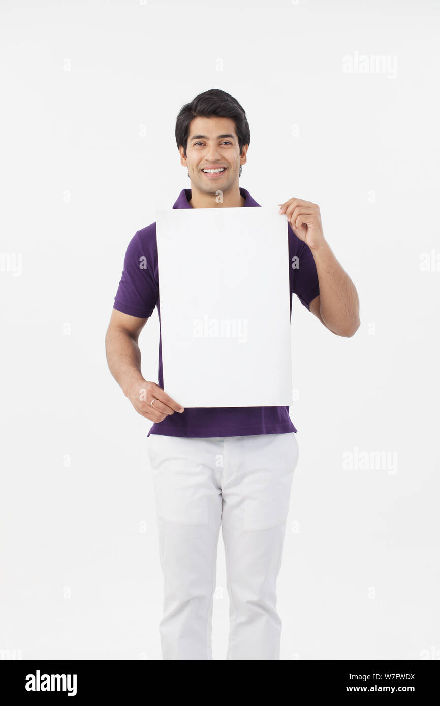 Young man showing a placard and smiling Stock Photo - Alamy