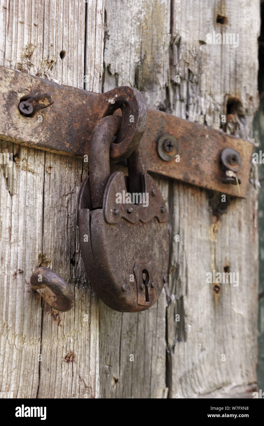 Old rusted lock on a rustic door with decorative natural weathered wood ...