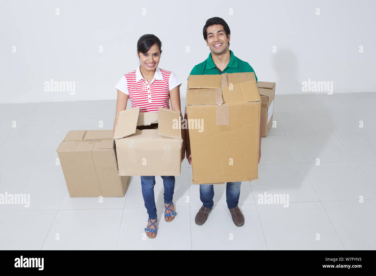 Couple holding cardboard boxes smiling Stock Photo - Alamy