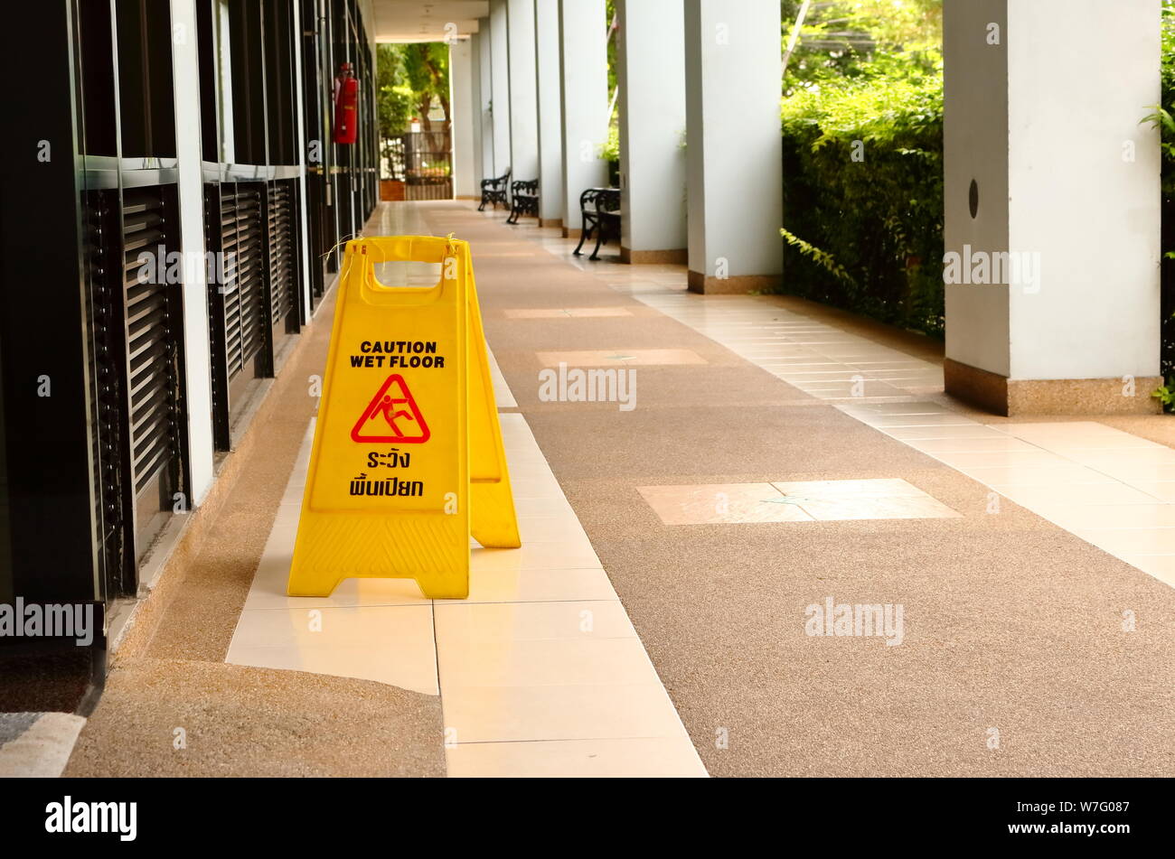 Closeup of warning sign standing on pavement read caution, wet floor ...