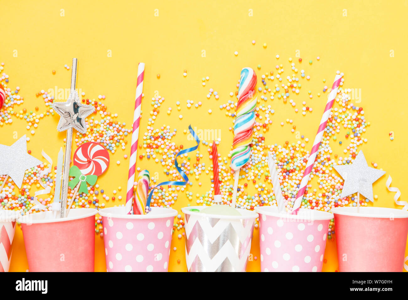 Birthday candies and accessory on yellow background Stock Photo - Alamy