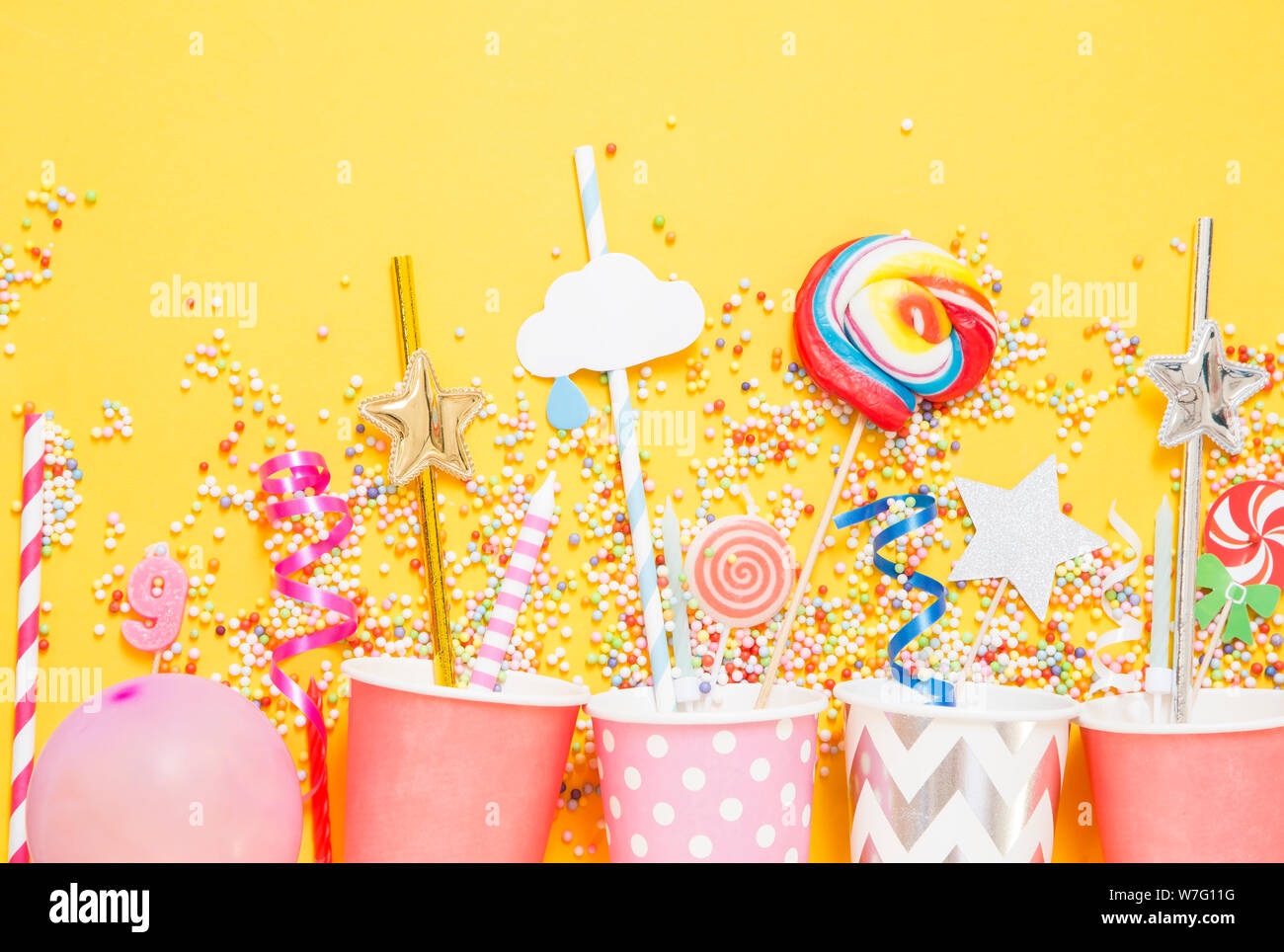 Birthday candies and accessory on yellow background Stock Photo - Alamy