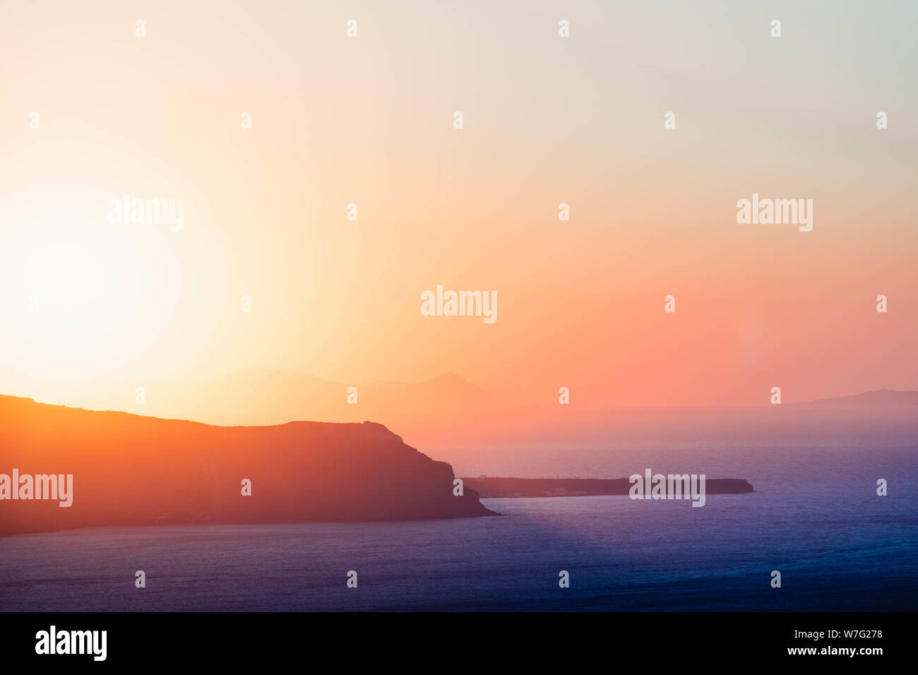 Beautiful sunset behind an island Stock Photo - Alamy