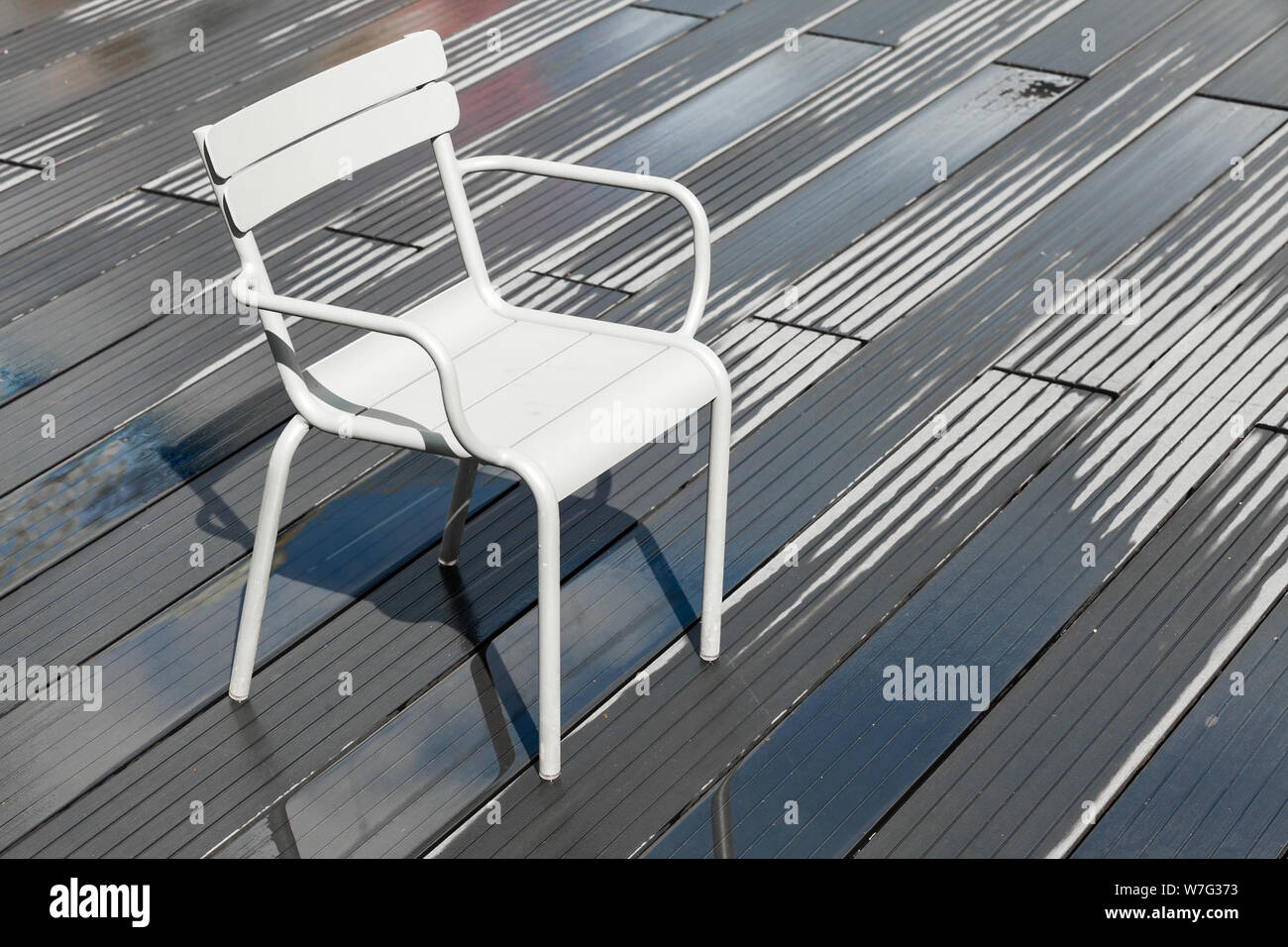 Empty white outdoor metal chair stands on wet wooden pier floor Stock ...