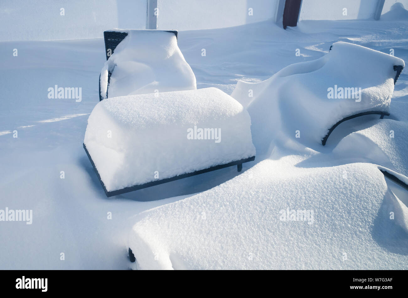 Outdoor benches and tables covered with snow are at the outdoor terrace ...