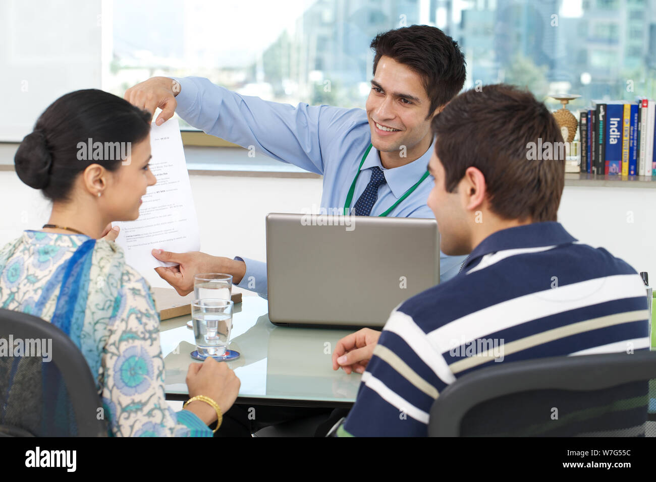 Executive explaining document to a couple Stock Photo - Alamy