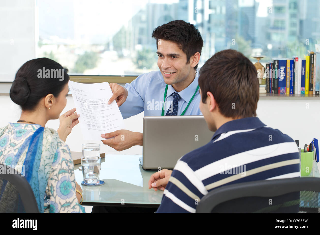 Executive explaining document to a couple Stock Photo - Alamy