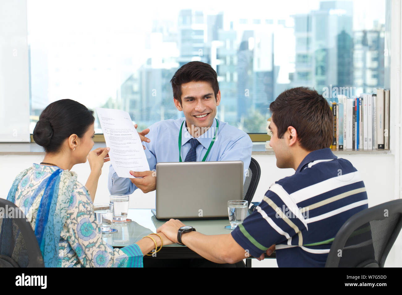 Executive explaining document to a couple Stock Photo - Alamy