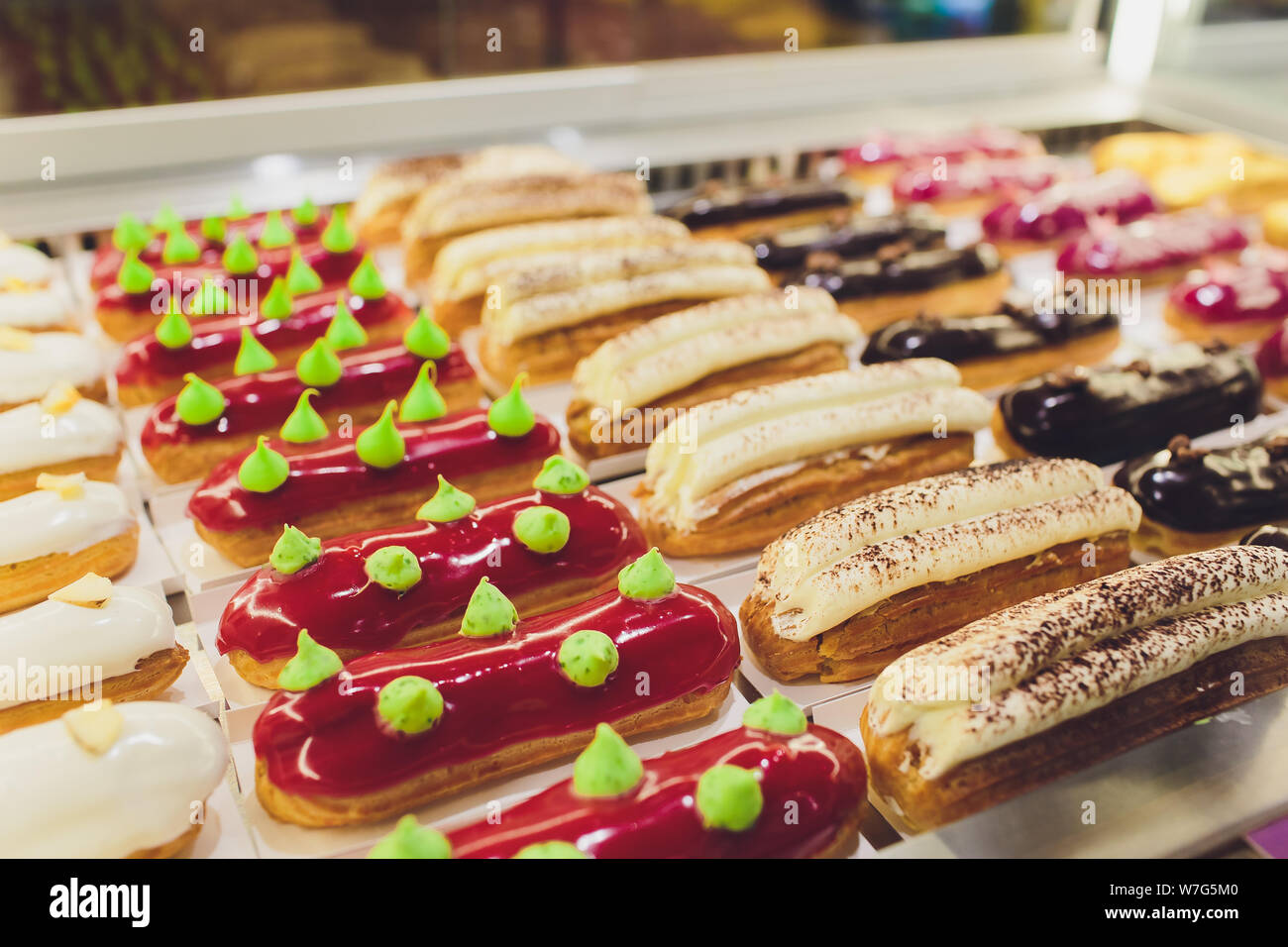 Close up of vendor's hands taking out cake from showcase in bakery ...