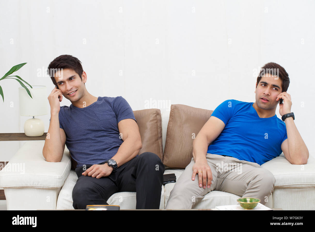 Two friends talking on mobile phone Stock Photo - Alamy