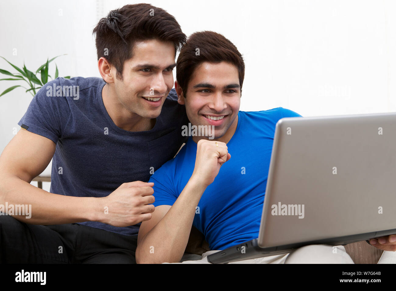 Two friends using a laptop smiling Stock Photo - Alamy