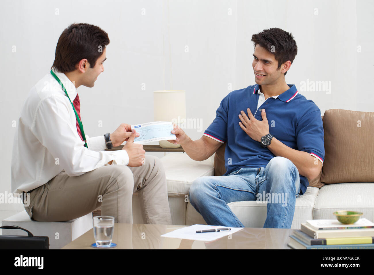 Financial advisor giving cheque to a young man Stock Photo - Alamy