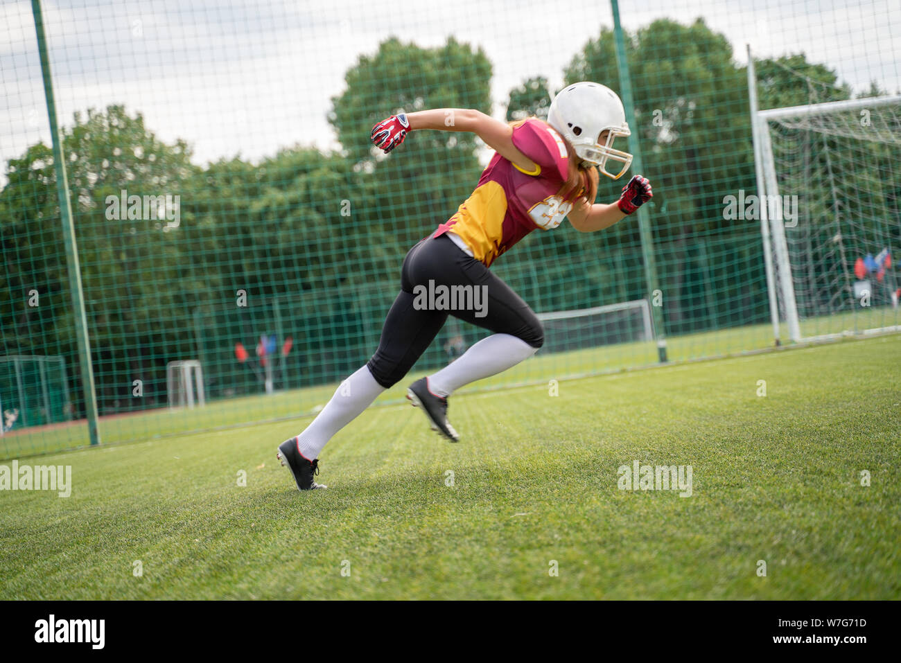 Photo of running American football female athlete Stock Photo - Alamy