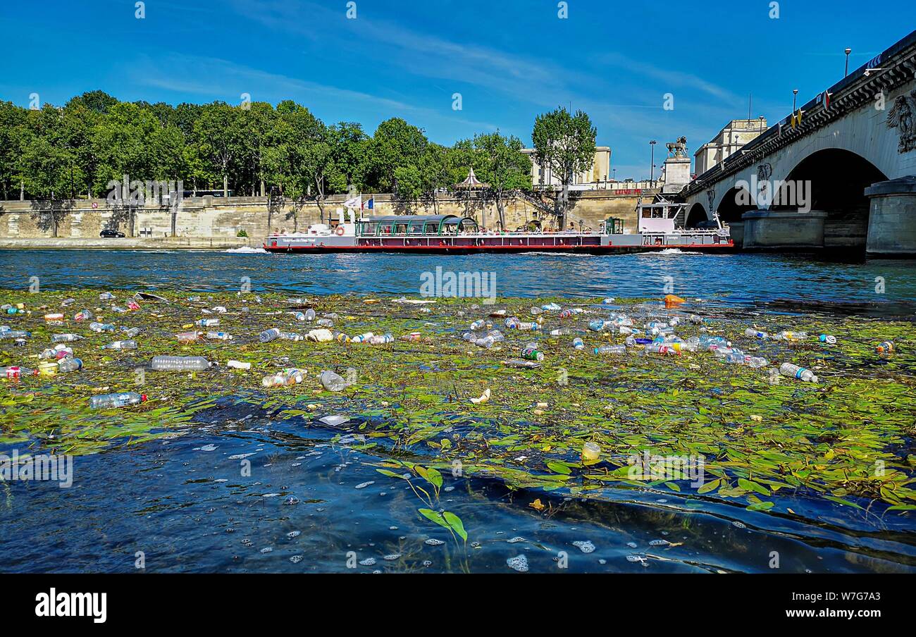 big amount of plastic waste swimming on water surface with water plants ...
