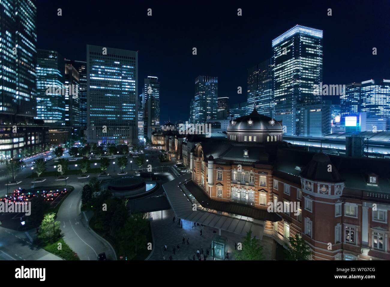 Tokyo Station in front of the illuminated skyline of the city, in May ...