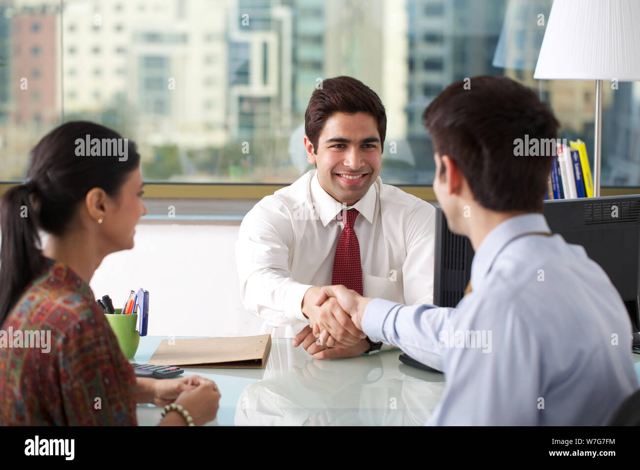 Financial advisor shaking hands with clients Stock Photo - Alamy